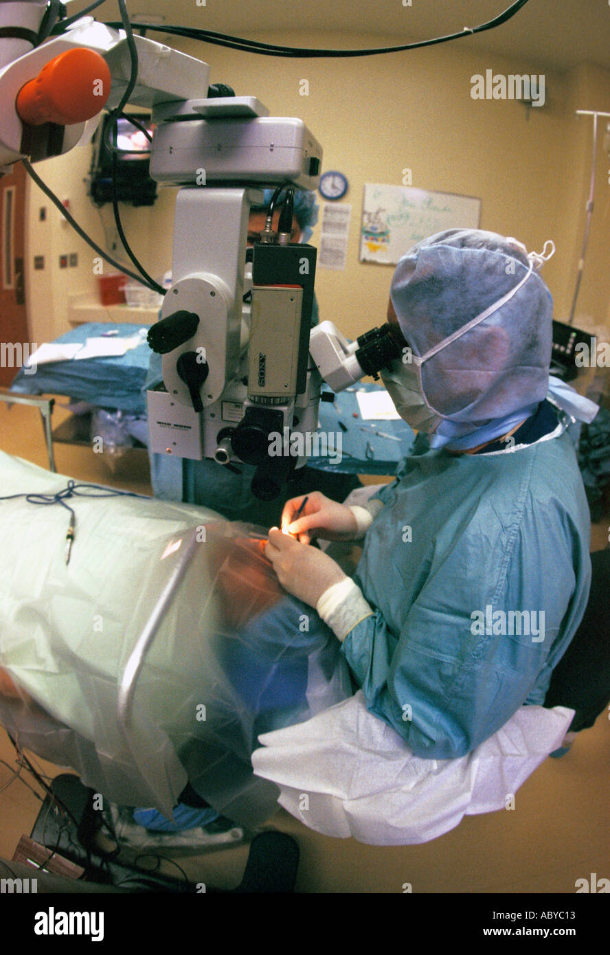 Ophthalmologist uses electronic overhead operating microscope to ...