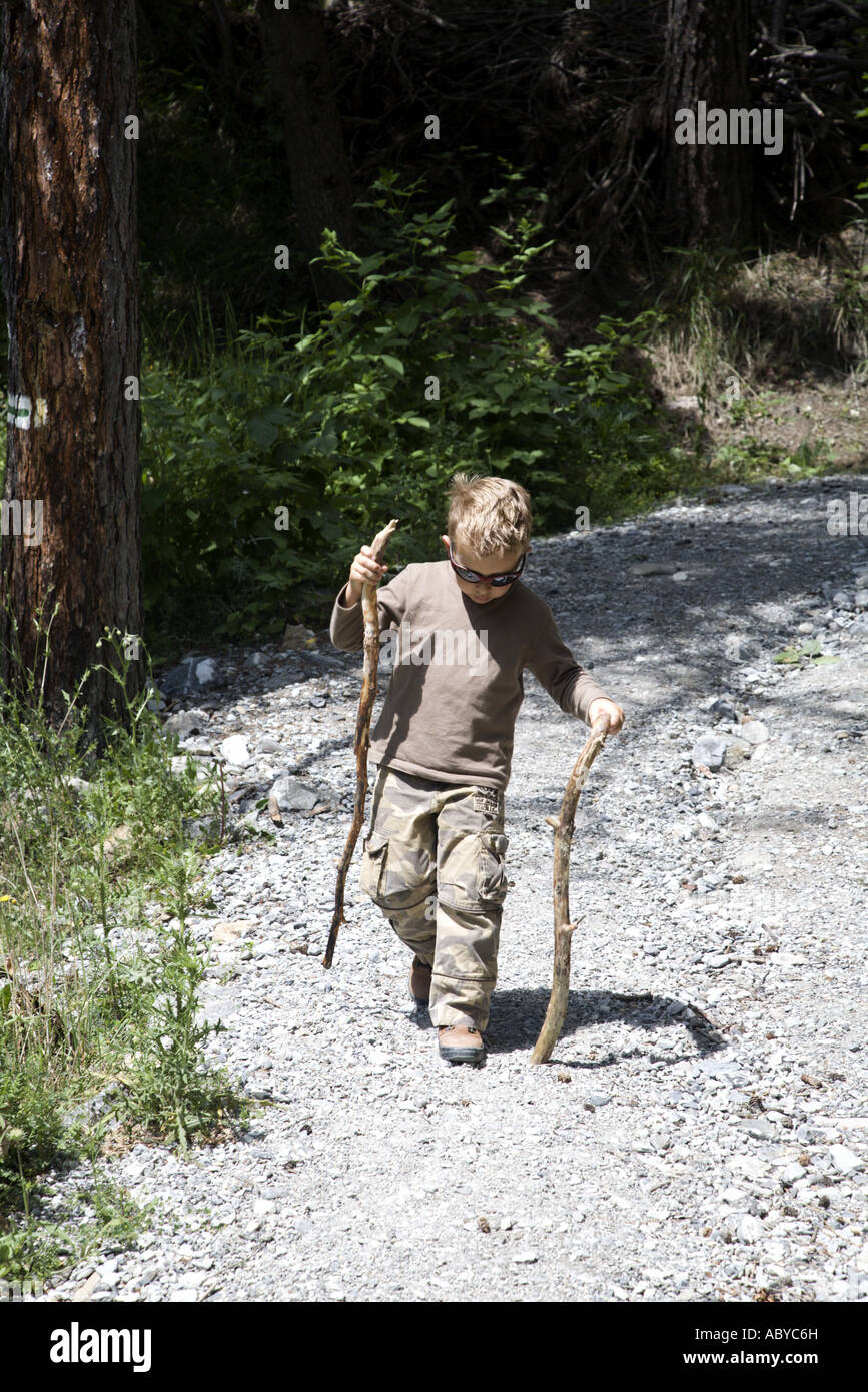 Little boy with 2 selfmade walking sticks on a walking path near St ...
