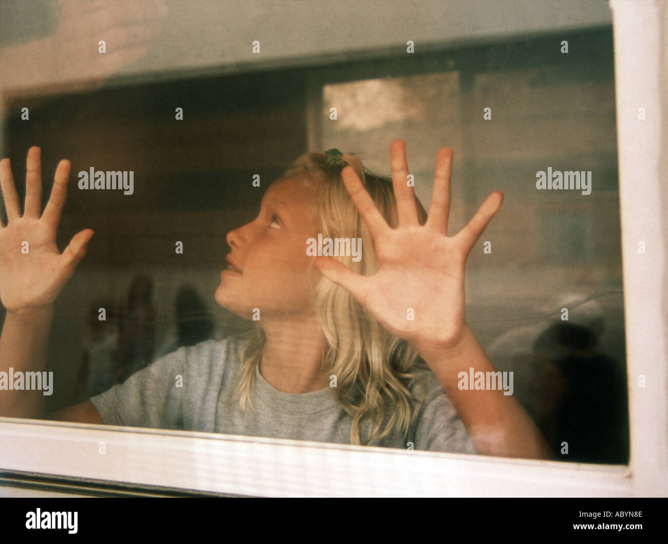 Girl raising a window with hands on window pane to escape a smoke ...