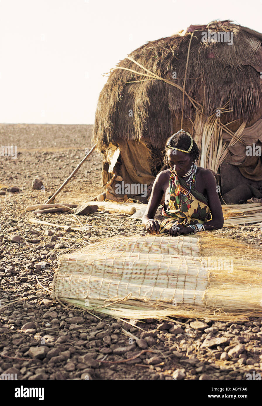 Gabbra married woman weaving a sisal mat for the roof of her hut ...