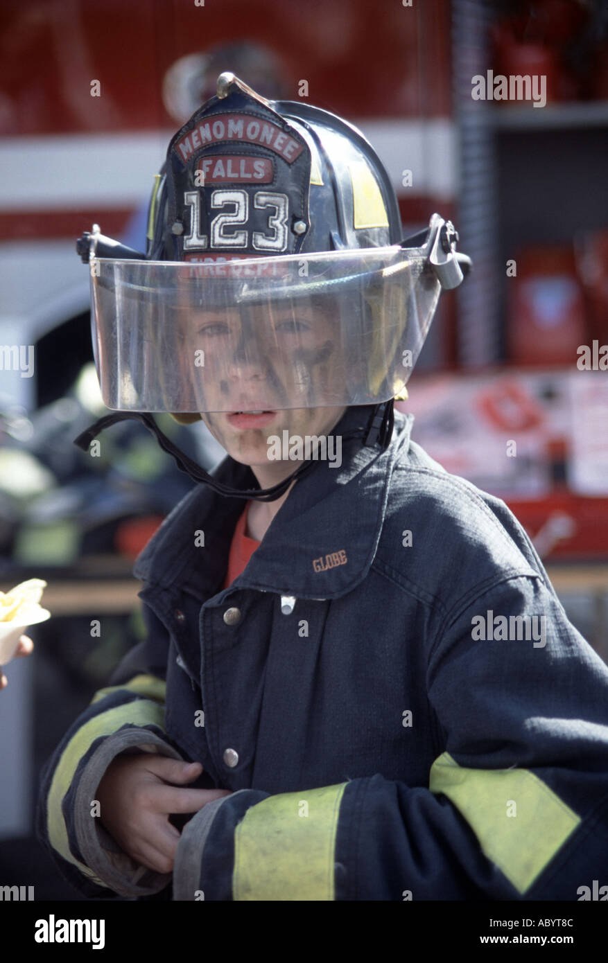 Boy trying on a fire fighting uniform dreaming of his future Stock ...