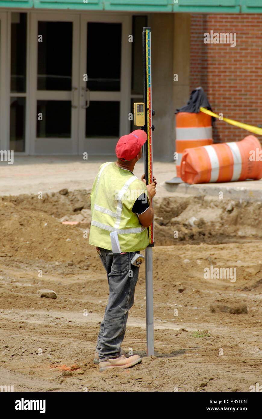 Worker with laser measuring device check for the proper depth during ...