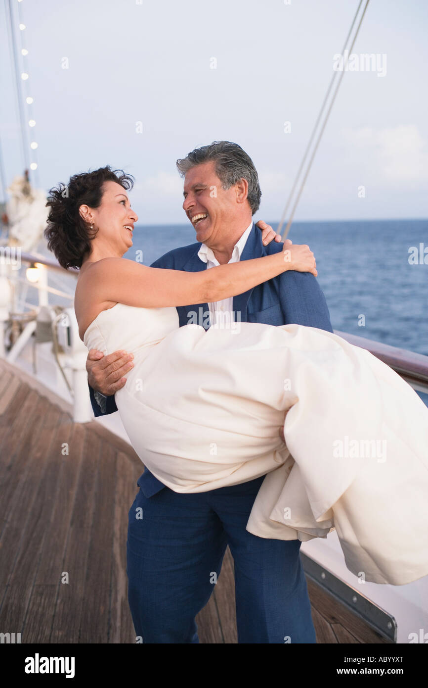 Newlywed man carrying his bride on boat deck Stock Photo - Alamy