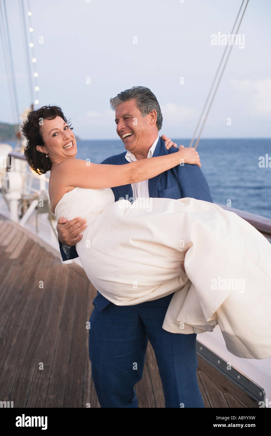 Newlywed man carrying his bride on boat deck Stock Photo - Alamy