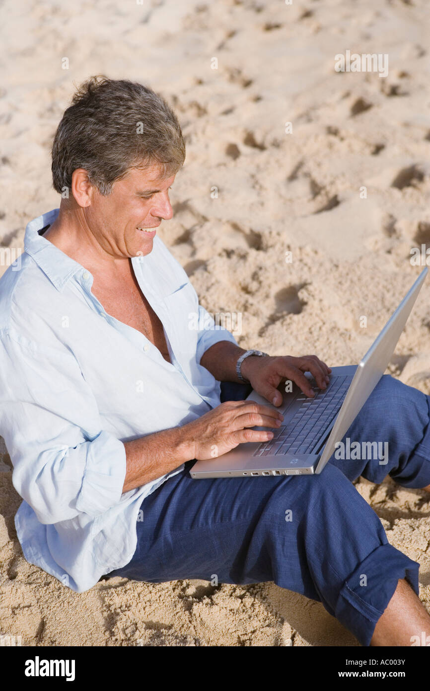 Man using laptop on beach Stock Photo - Alamy