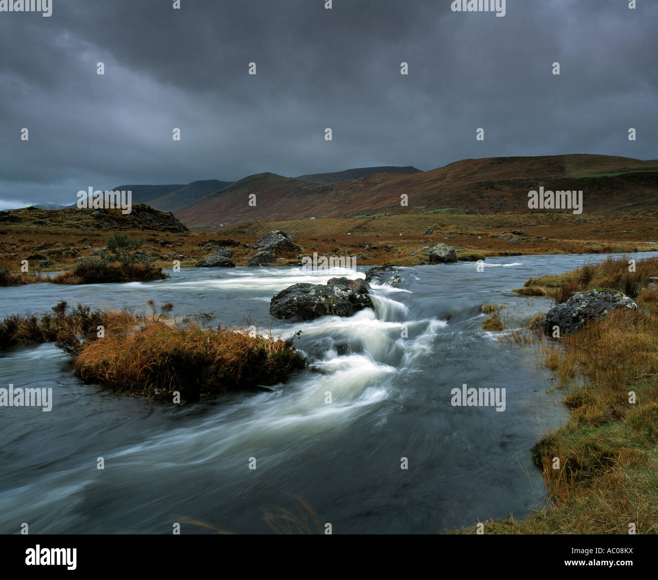 county mayo, connemara, river in flood flowing down irish valley ...