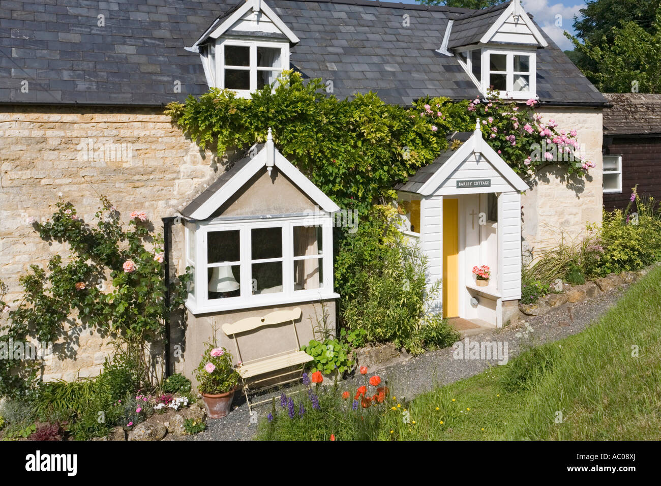 A stone cottage with a Welsh slate roof in the Cotswold village of ...