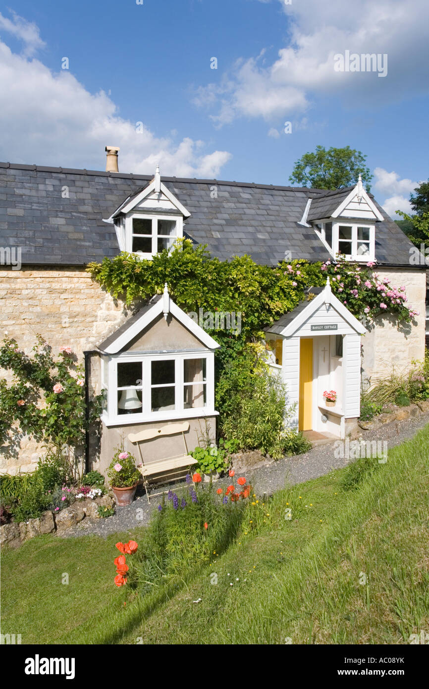 A stone cottage with a Welsh slate roof in the Cotswold village of ...