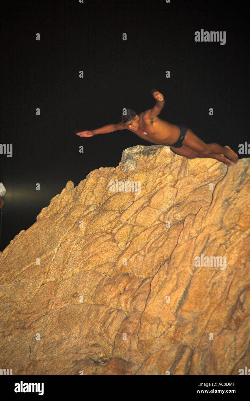 Cliff diver, clavadista, diving off cliff face at night, La Quebrada ...