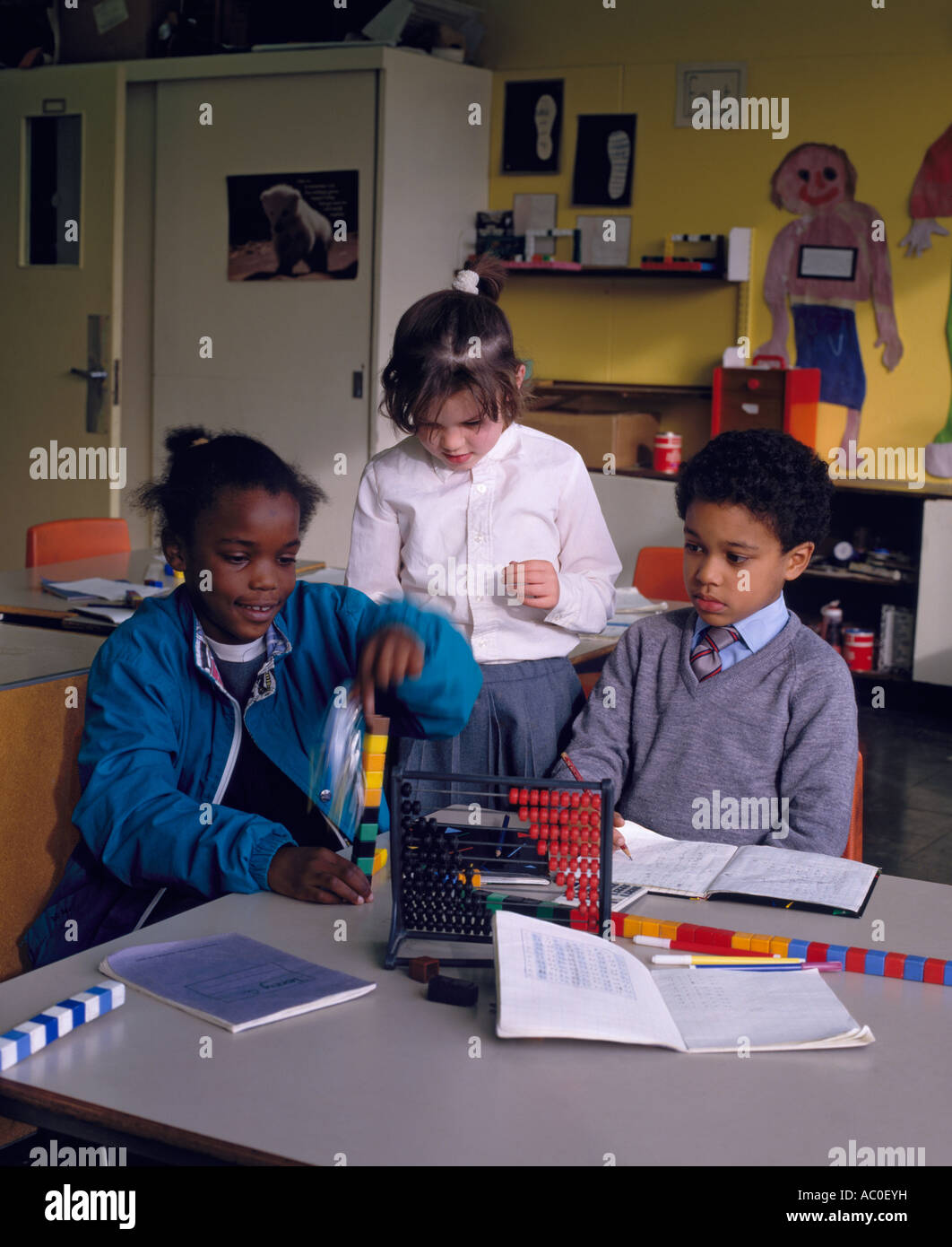 Three primary school children in classroom Stock Photo - Alamy