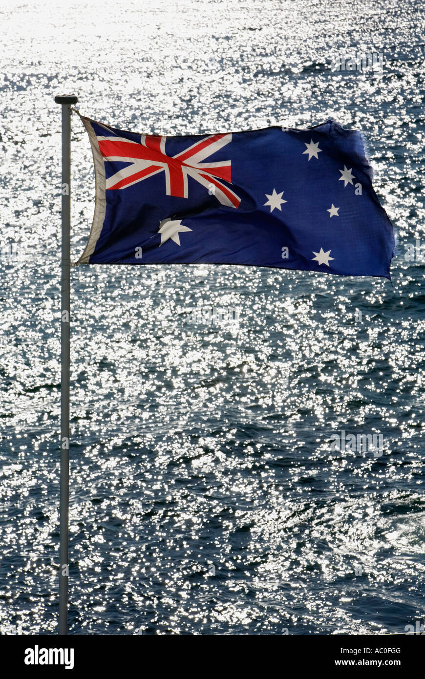 The Australian flag flutters in the breeze with a backdrop of the ...