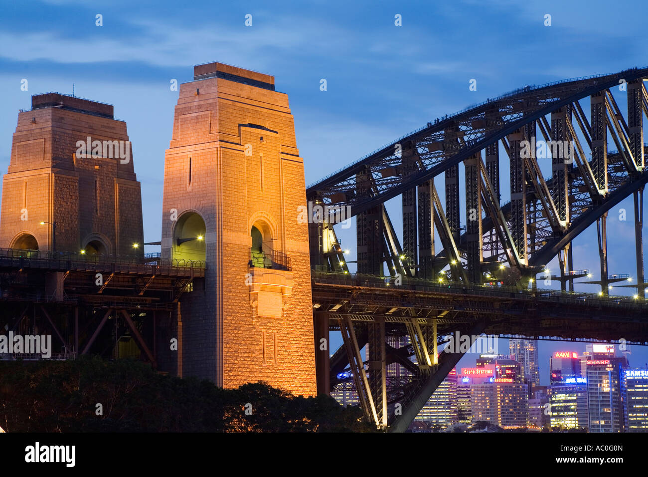 The southern pylons of the Sydney Harbour Bridge with the lights of the ...