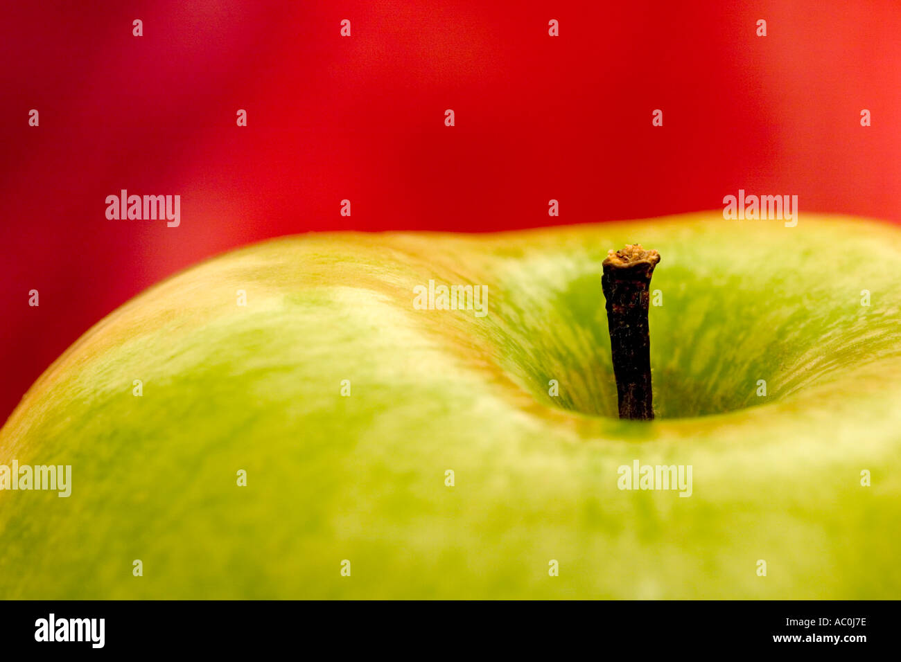 Green apple with red background Stock Photo - Alamy
