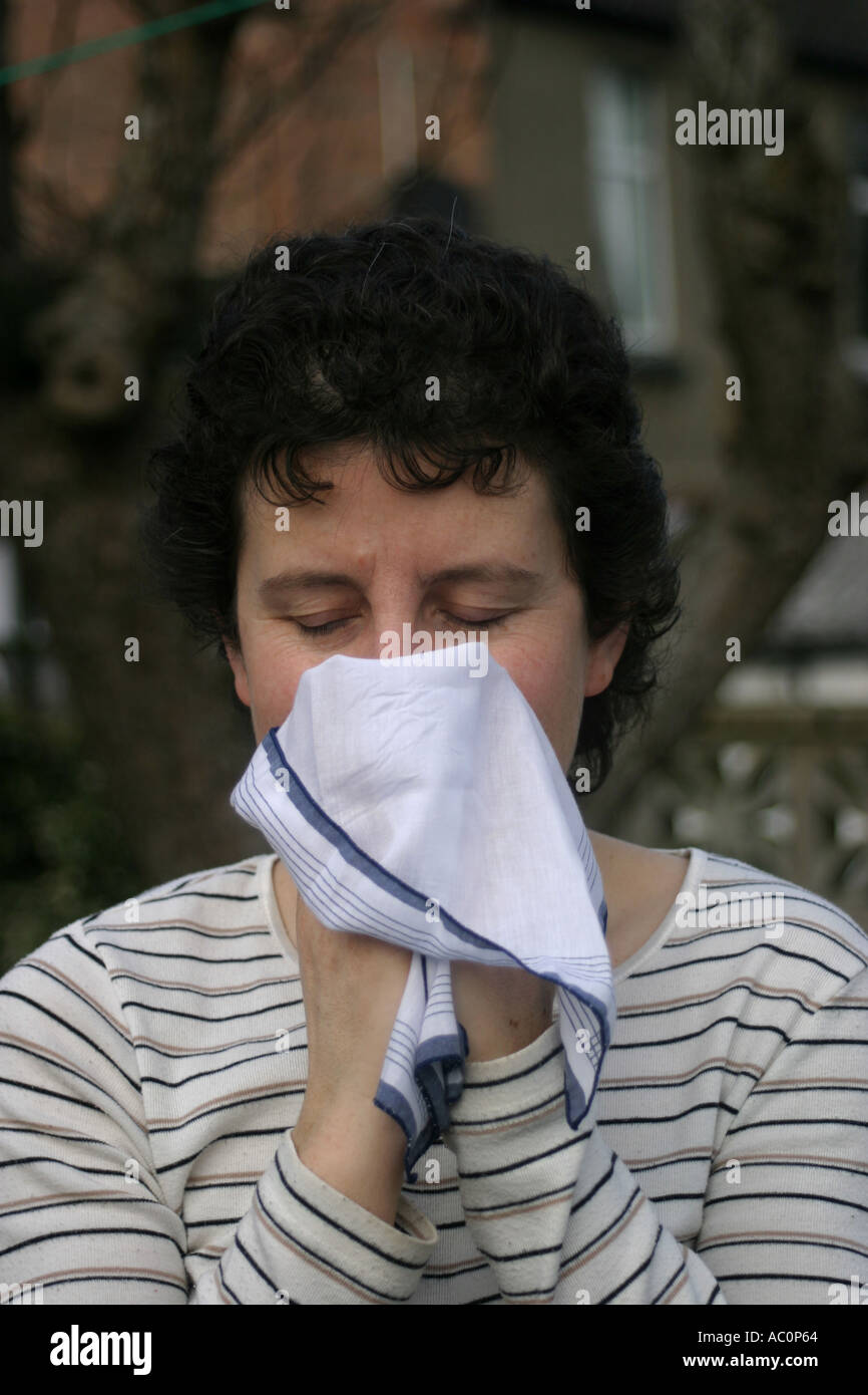 woman sneezing into handkerchief Stock Photo - Alamy