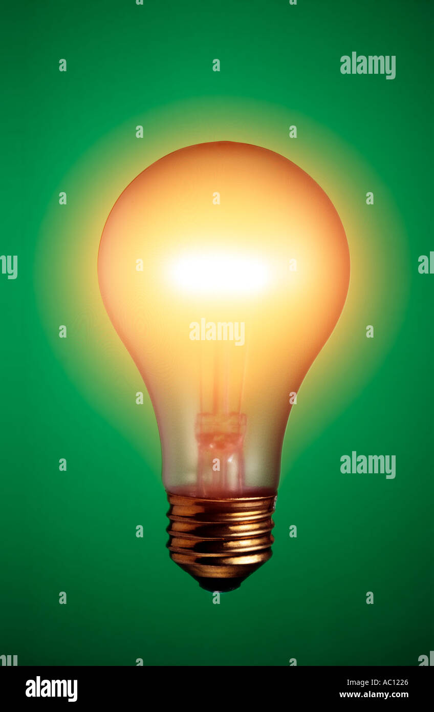 glowing light bulb on green background Stock Photo - Alamy