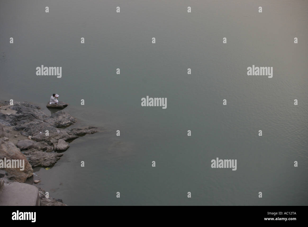 Praying by the holy river ganges Stock Photo - Alamy