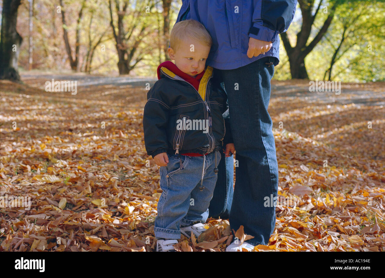 Young Boy Standing Beside His Mother Pouting Stock Photo - Alamy