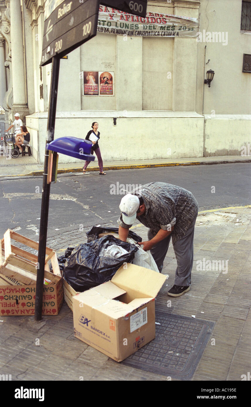 Third world poverty a man looks for food in rubbish bags for something ...