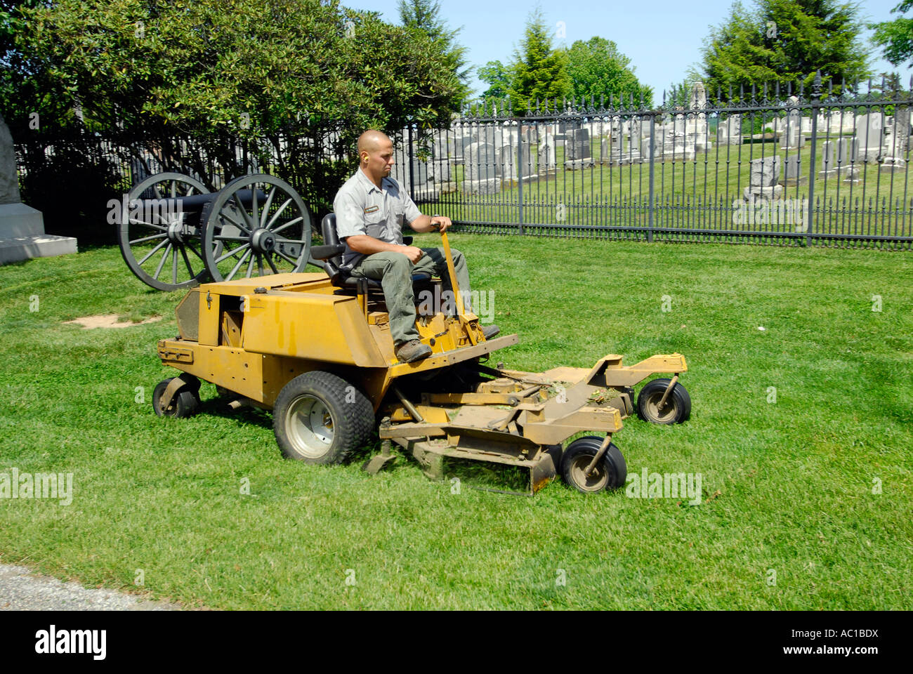 Maintenance man mows grass on a zero turn lawn mower Stock Photo - Alamy