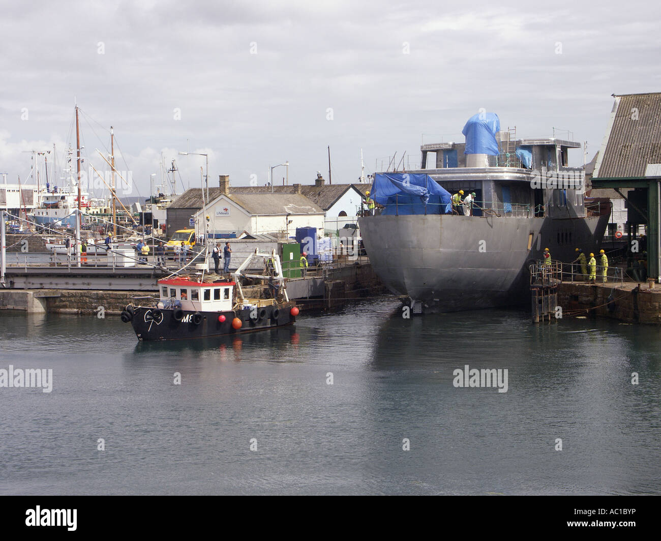 A tug pulling a ship from the Penzance dry dock. One of a series of 10 ...