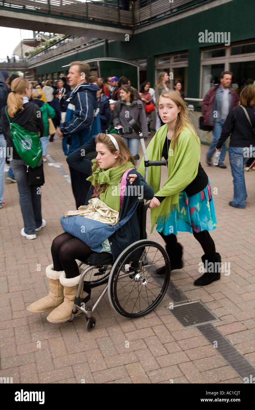 Girl pushing the wheelchair of a friend at Wimbledon tennis ...