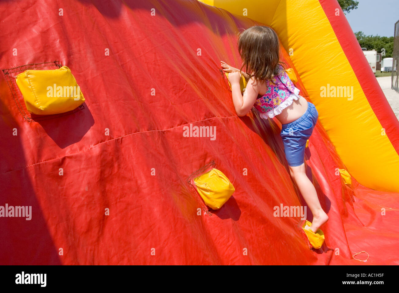 Kids going through inflatable obstacle course at local fair Stock Photo ...