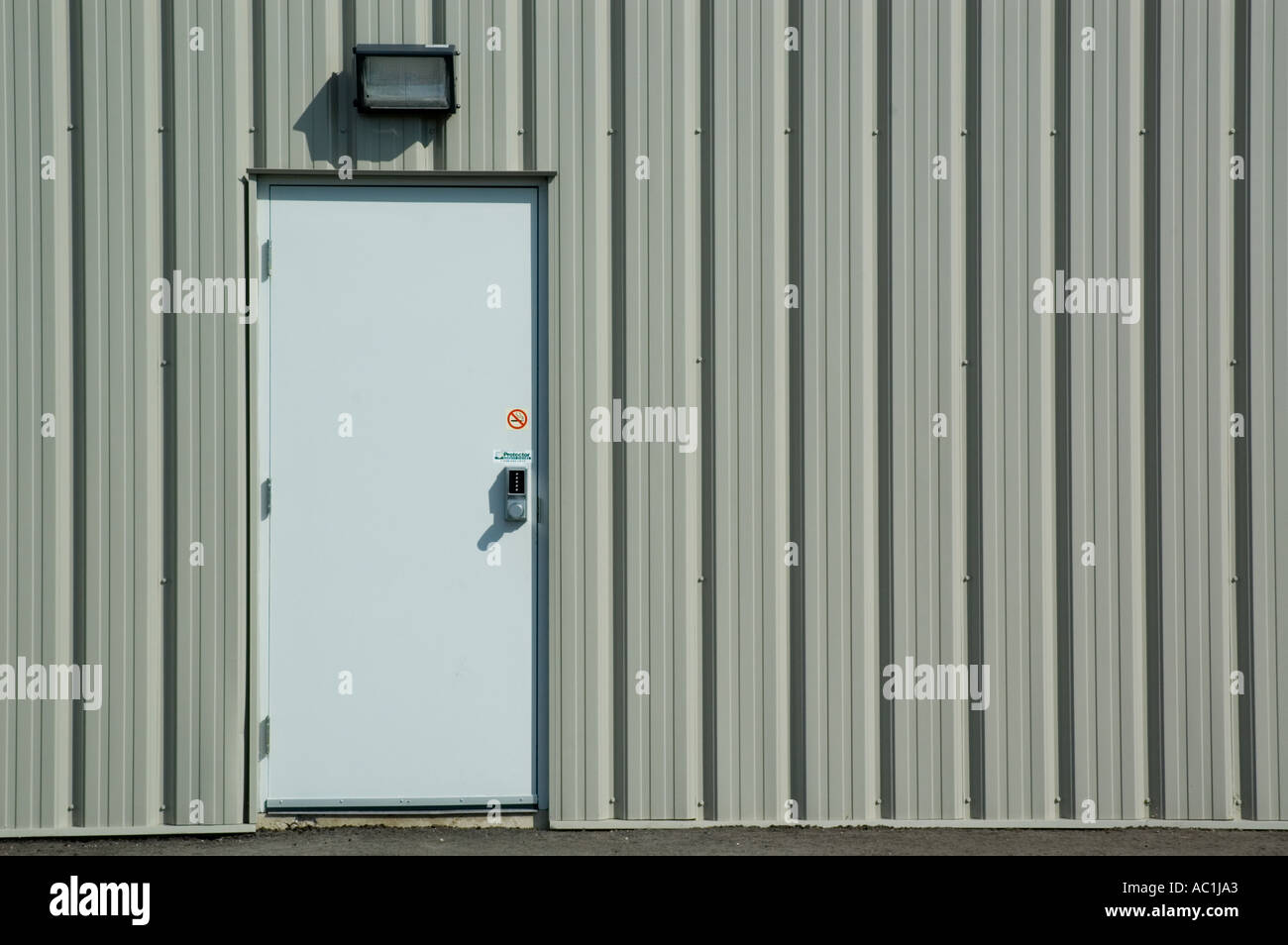 Corrugated metal wall with white door Stock Photo - Alamy