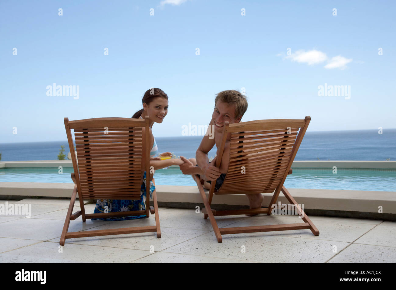 Couple sitting in deckchairs at swimmingpools Stock Photo - Alamy