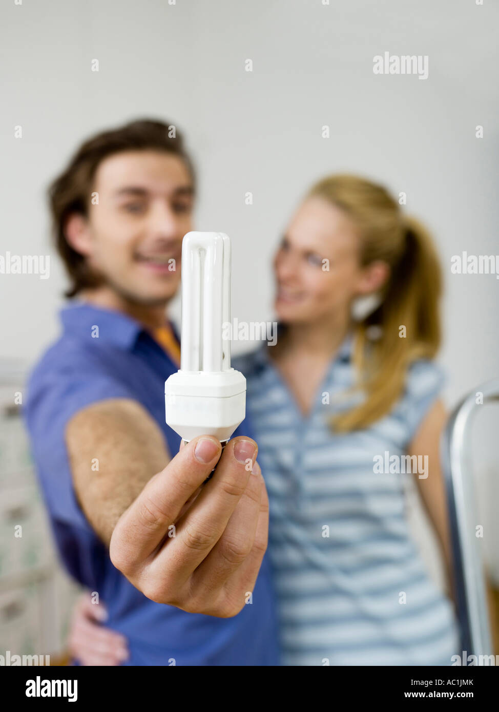 Couple embracing, man holding bulb Stock Photo - Alamy