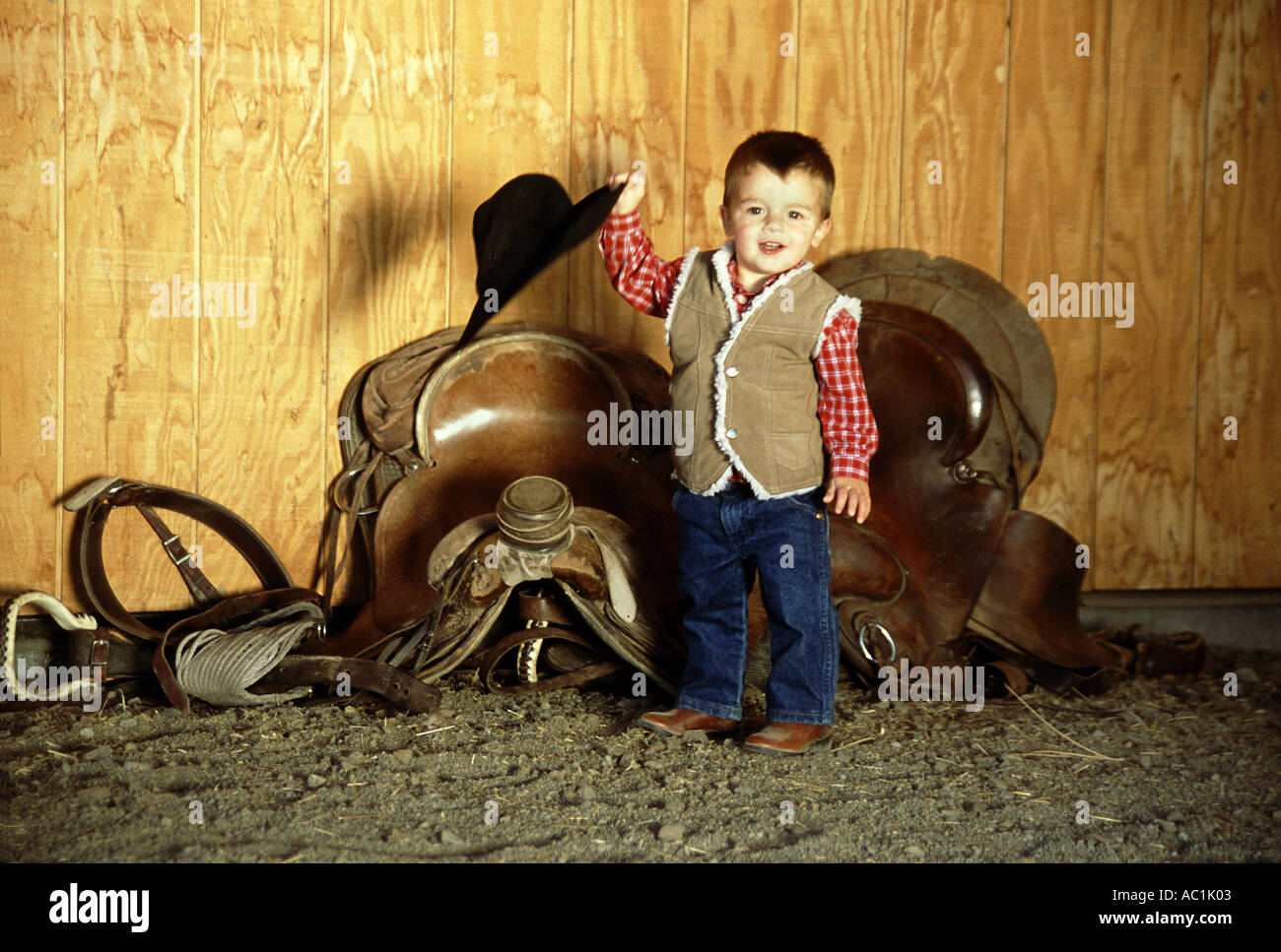 Young cowboy portrait with a saddle Stock Photo - Alamy