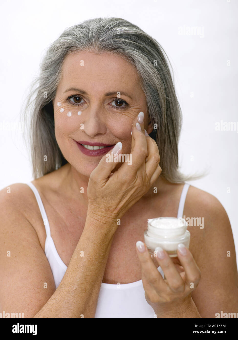 Senior woman applying face cream, portrait Stock Photo - Alamy