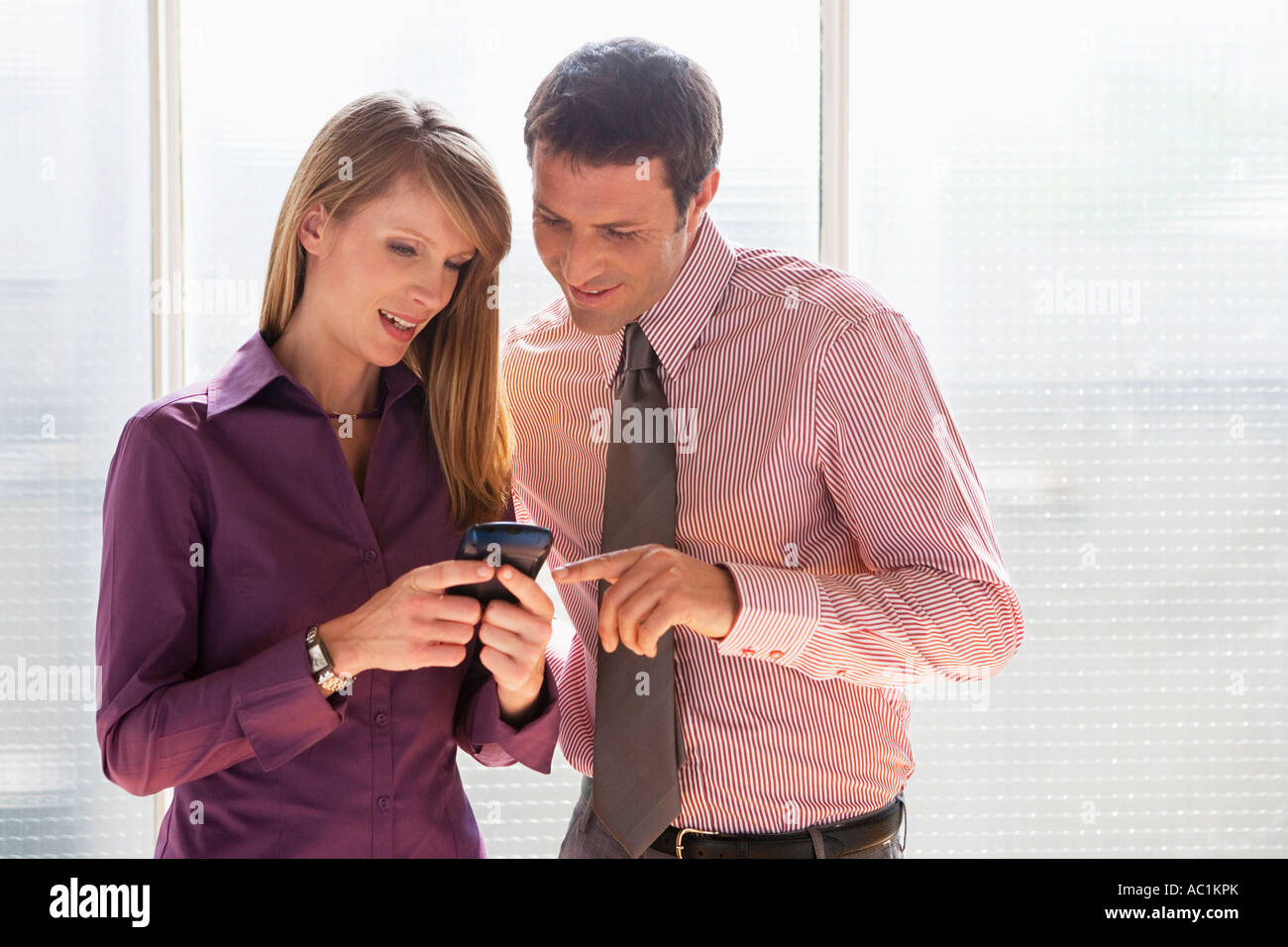 Business man and woman using mobile phone, teamwork Stock Photo - Alamy