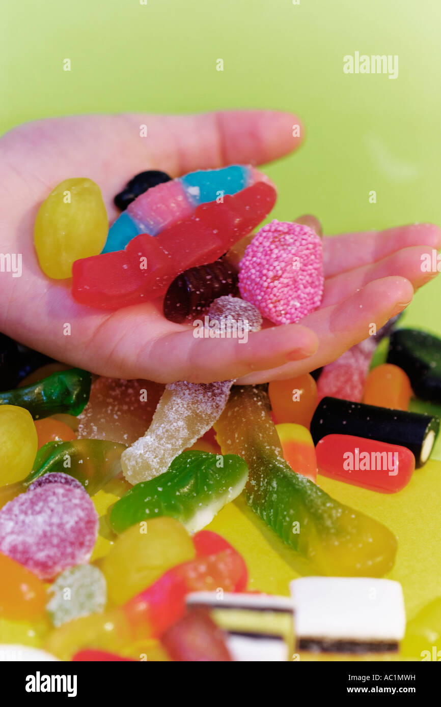 child's hand holding assorted candies Stock Photo - Alamy