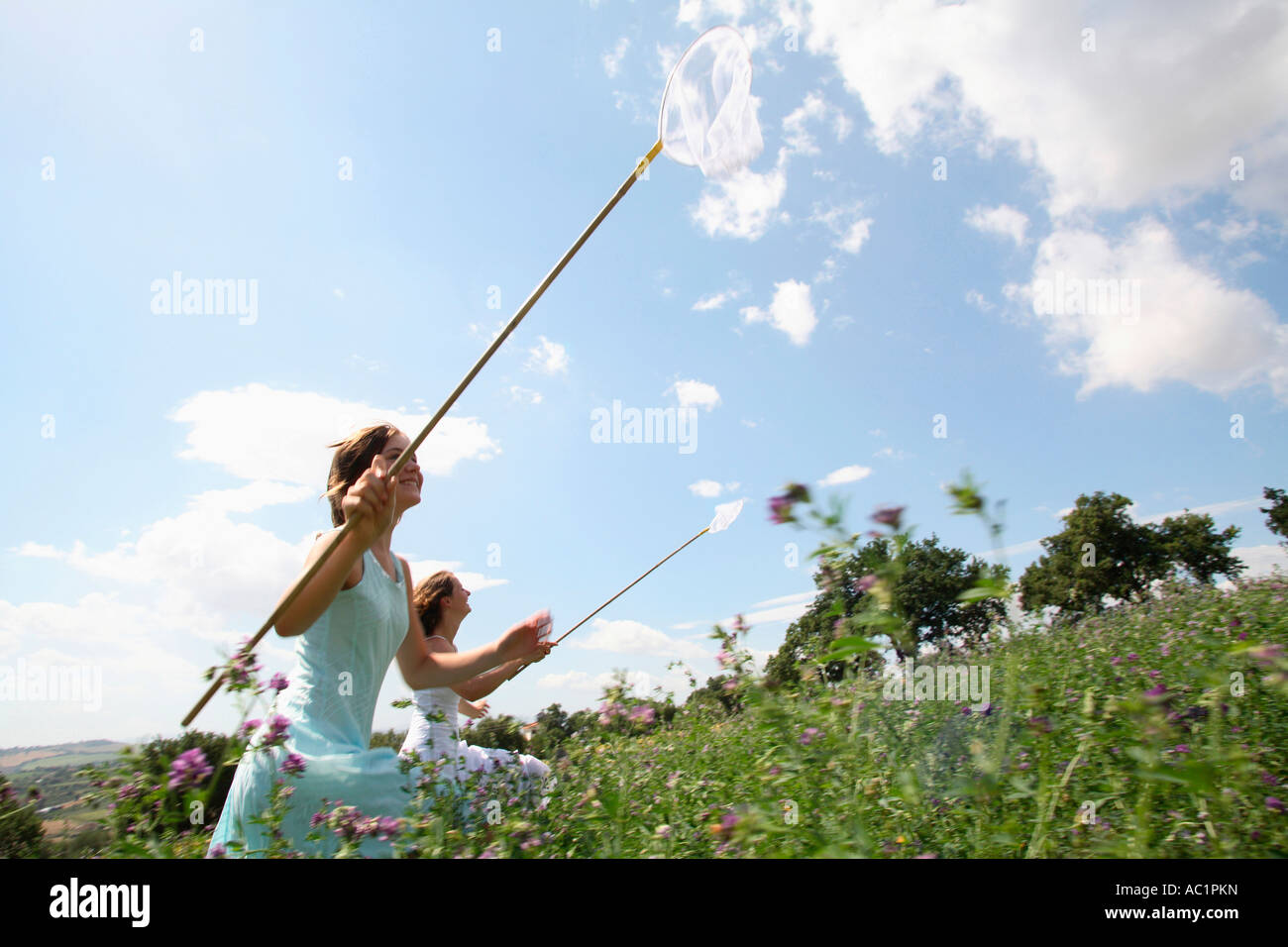 Two young women catching butterflies Stock Photo - Alamy