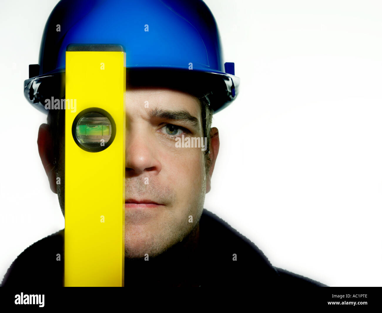 a builder in safety hard hat holding a spirit level Stock Photo - Alamy