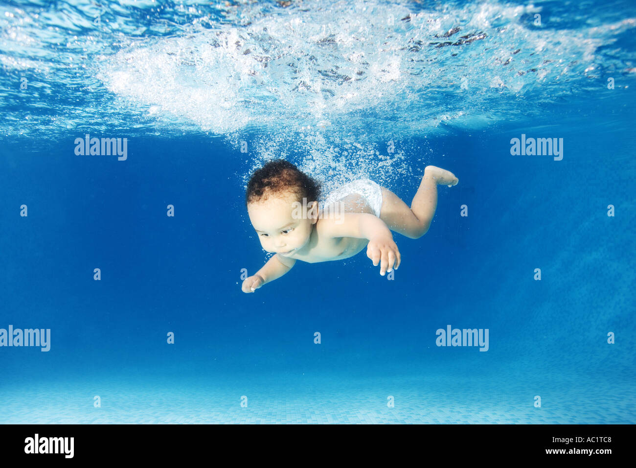 Baby underwater in pool on blue background Stock Photo - Alamy
