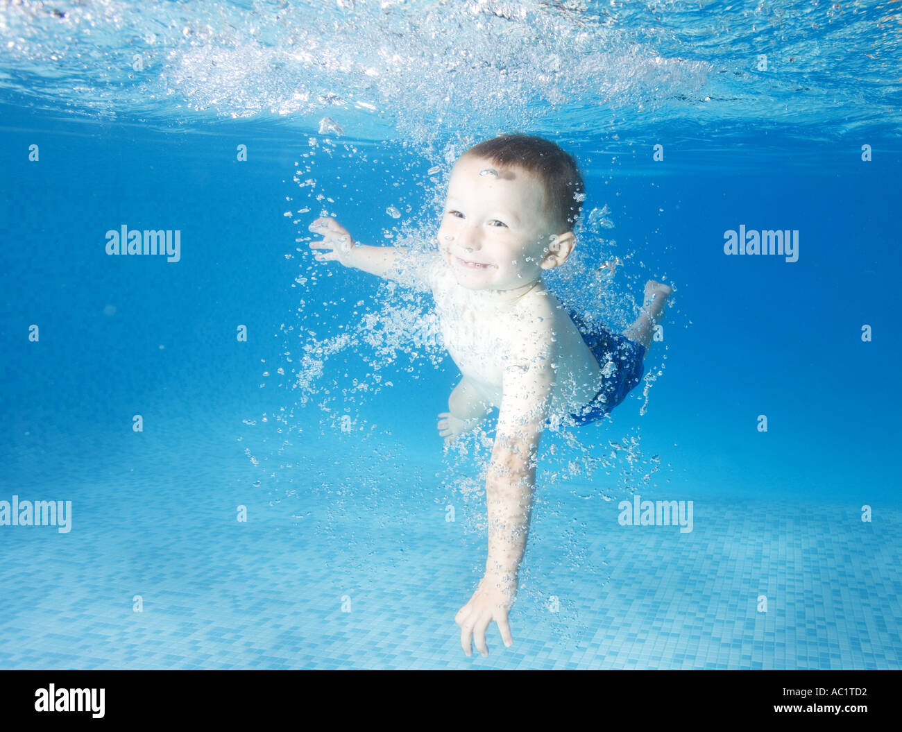 Baby underwater in pool on blue background Stock Photo - Alamy