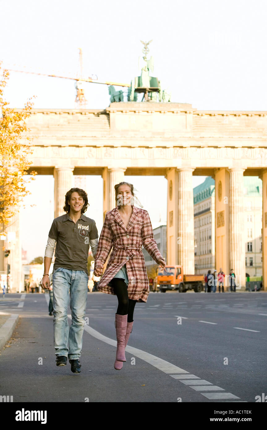 Young couple running in street, hand in hand Stock Photo - Alamy