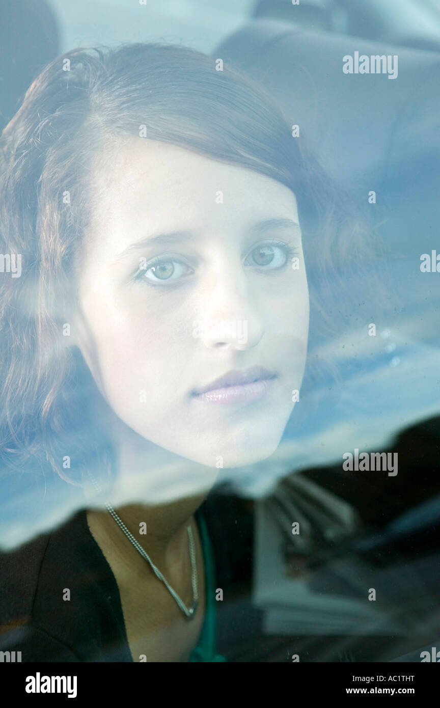 young woman looking through window pane, portrait Stock Photo - Alamy