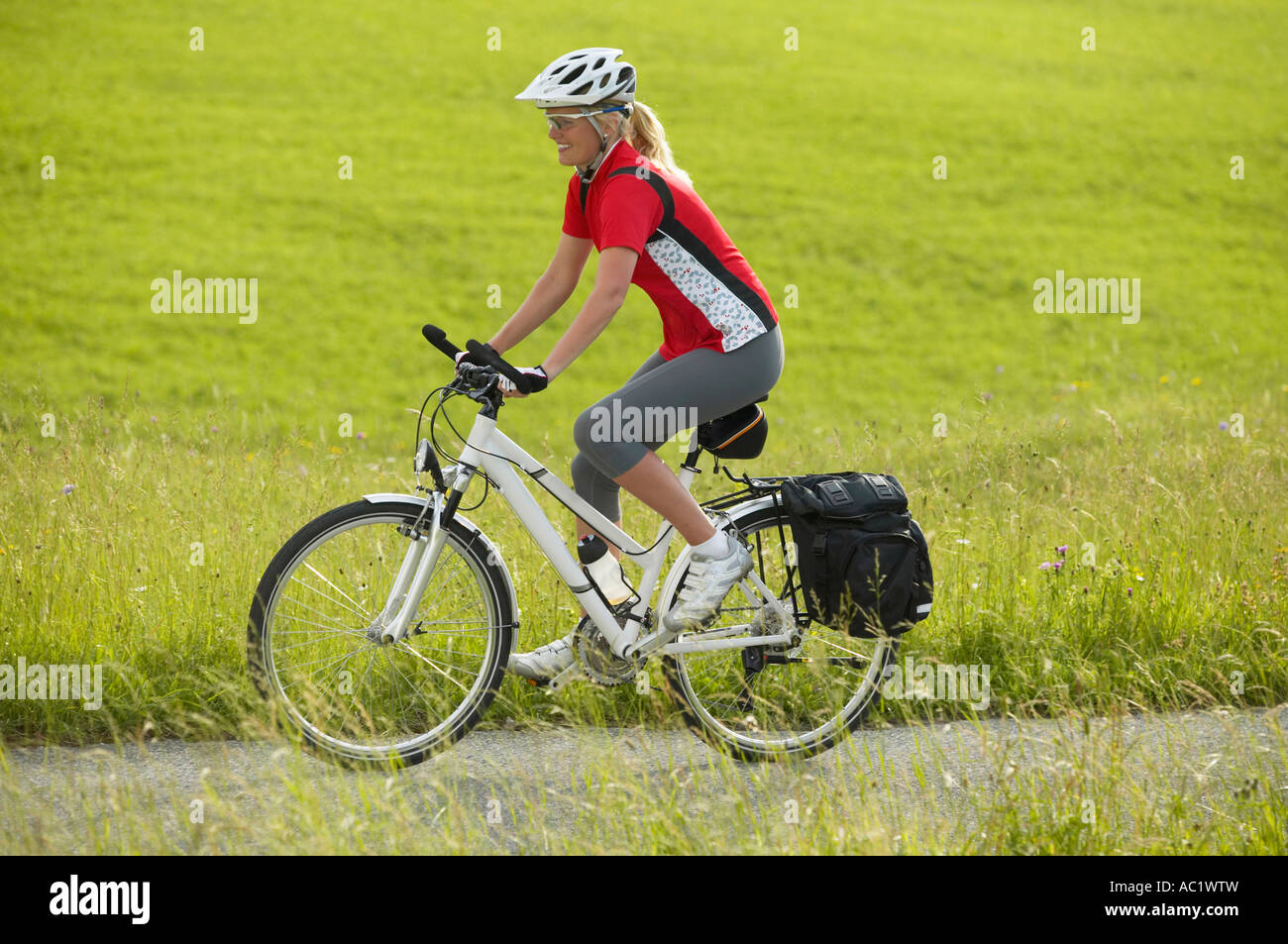 Female racing cyclist on the way Stock Photo - Alamy
