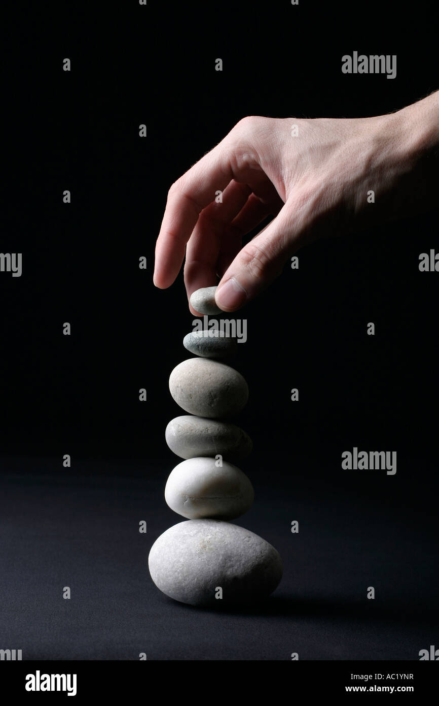 Person balancing stones close up Stock Photo - Alamy