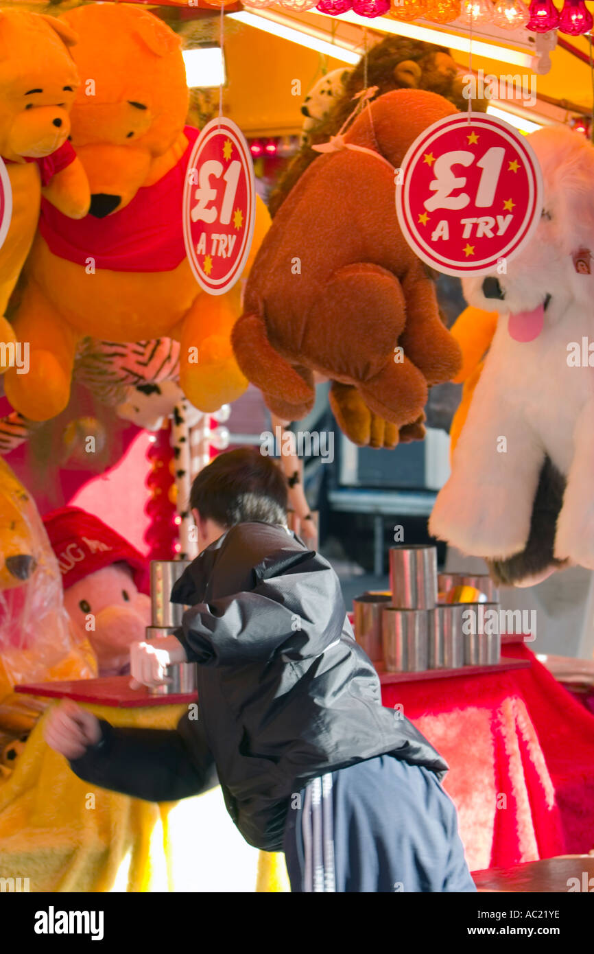 Man trying to knock over a stack of tins fairground sideshow game Stock ...