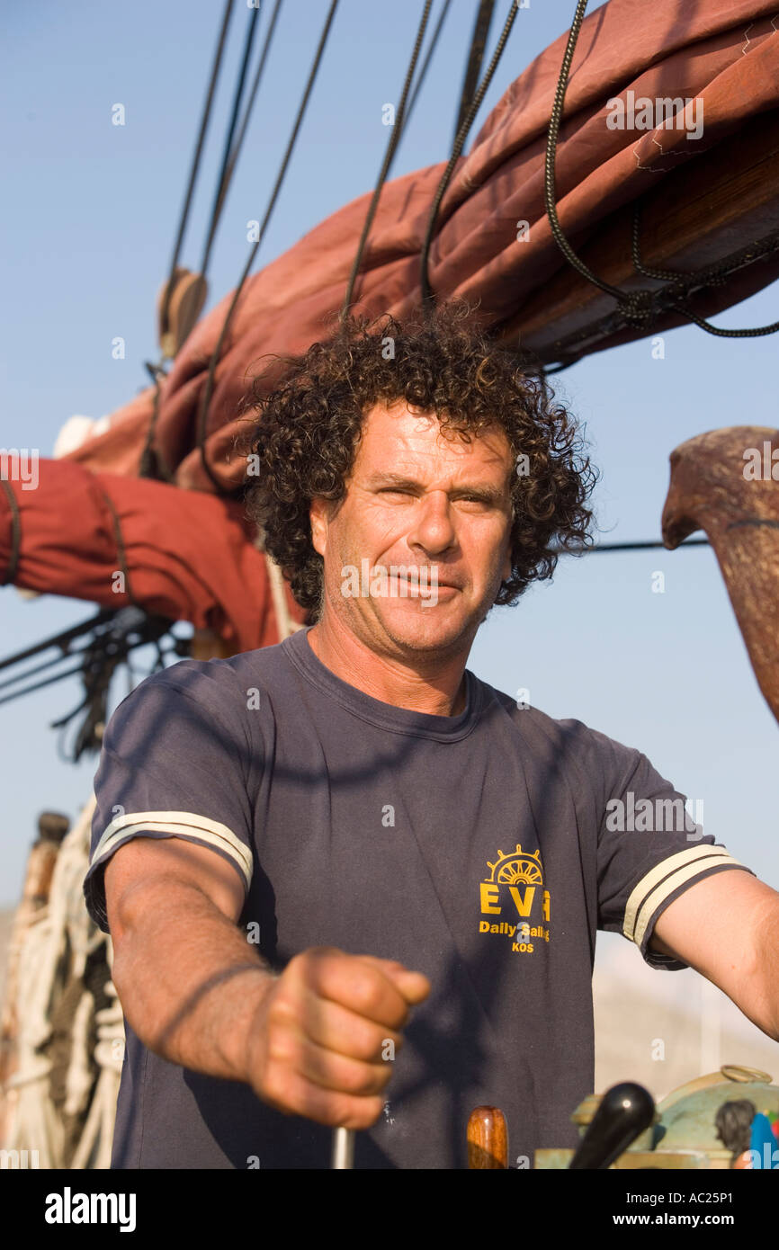 Captain standing on the wheel of a sailing boat during a boat trip to a ...