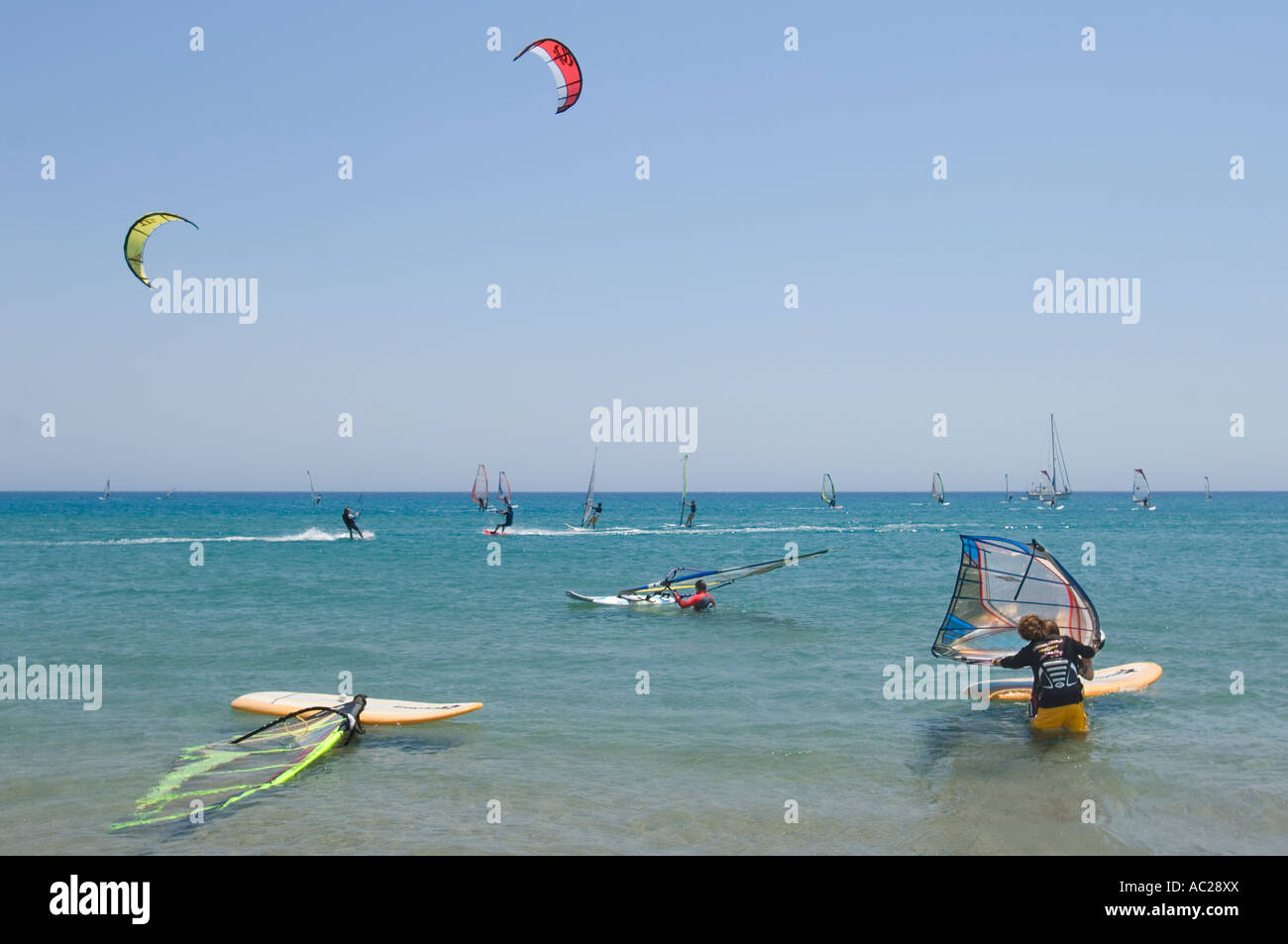A windsurfing instuctor teaching a student the basic skills of the ...