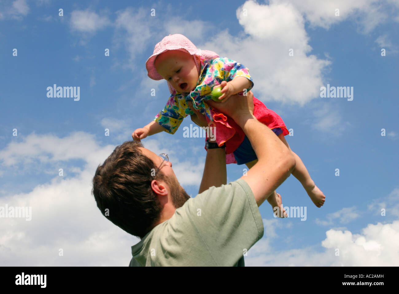 a happy father raising his baby girl high up in the air Stock Photo - Alamy