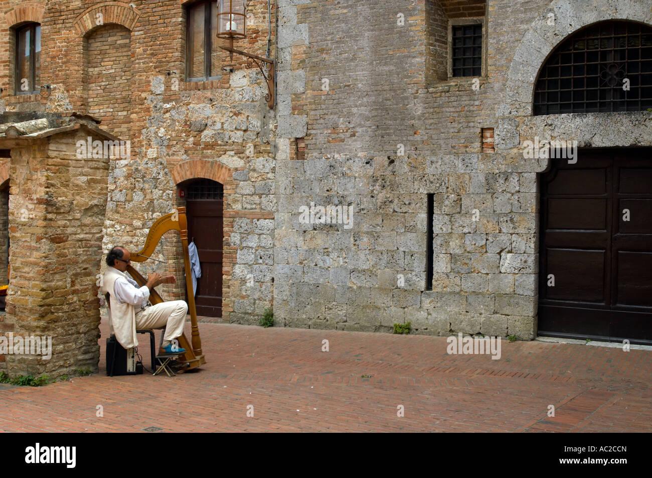 Man playing harp in square in San Gimignano Tuscany Italy Stock Photo ...