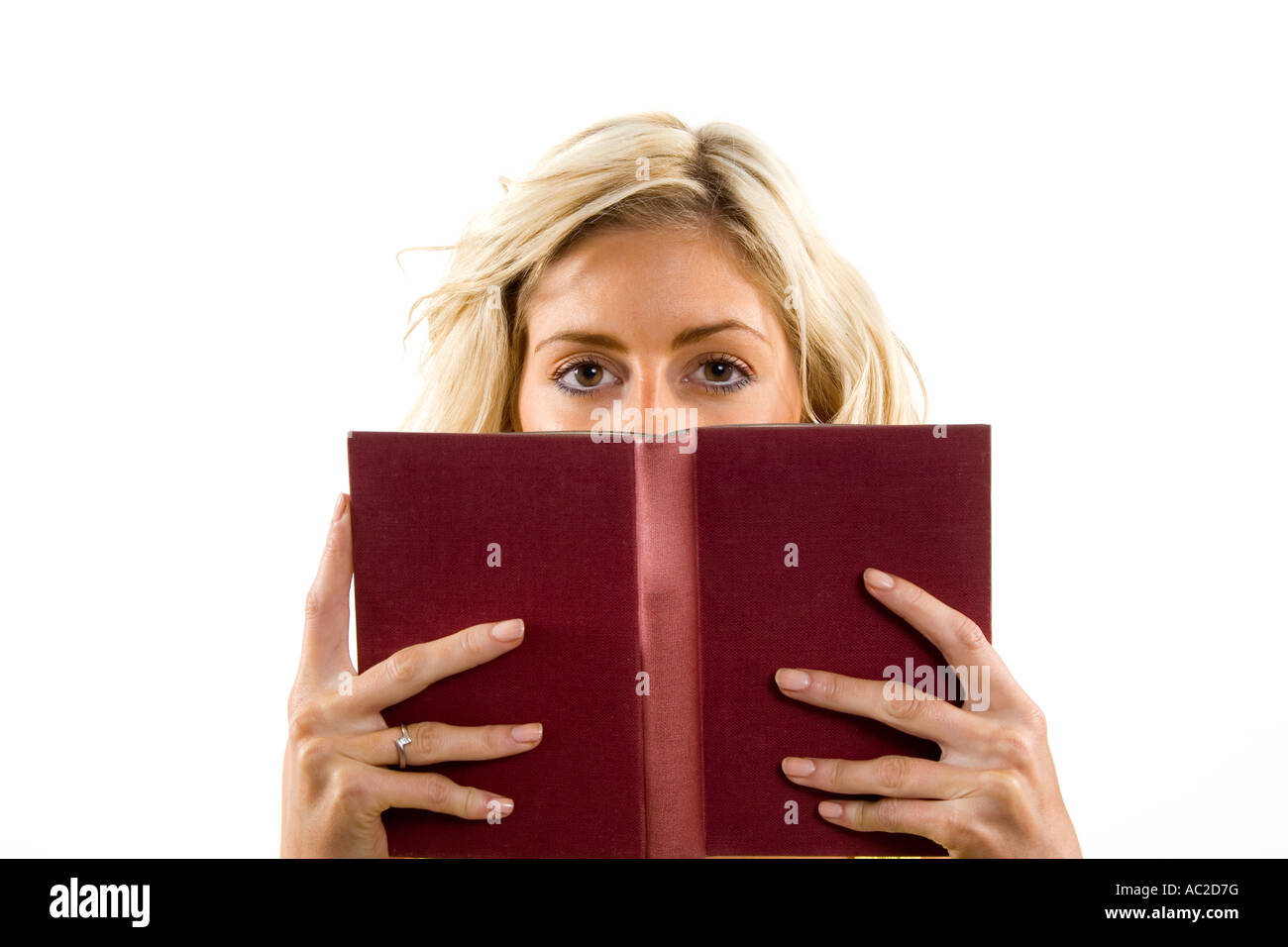 woman looking over the top of a book Stock Photo - Alamy
