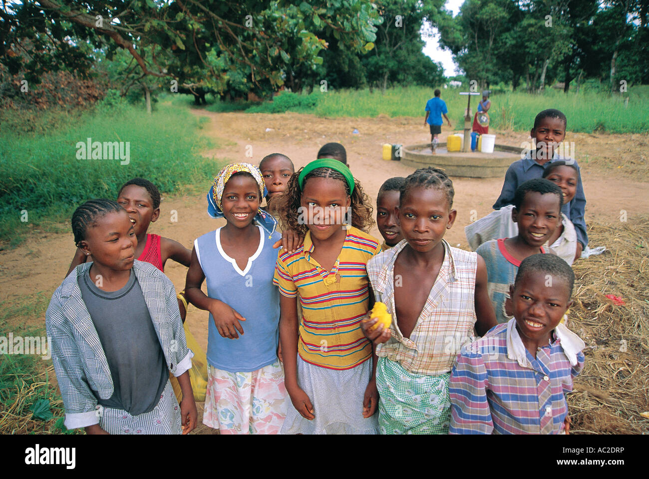 Happy African children pose for a photograph In the background a ...