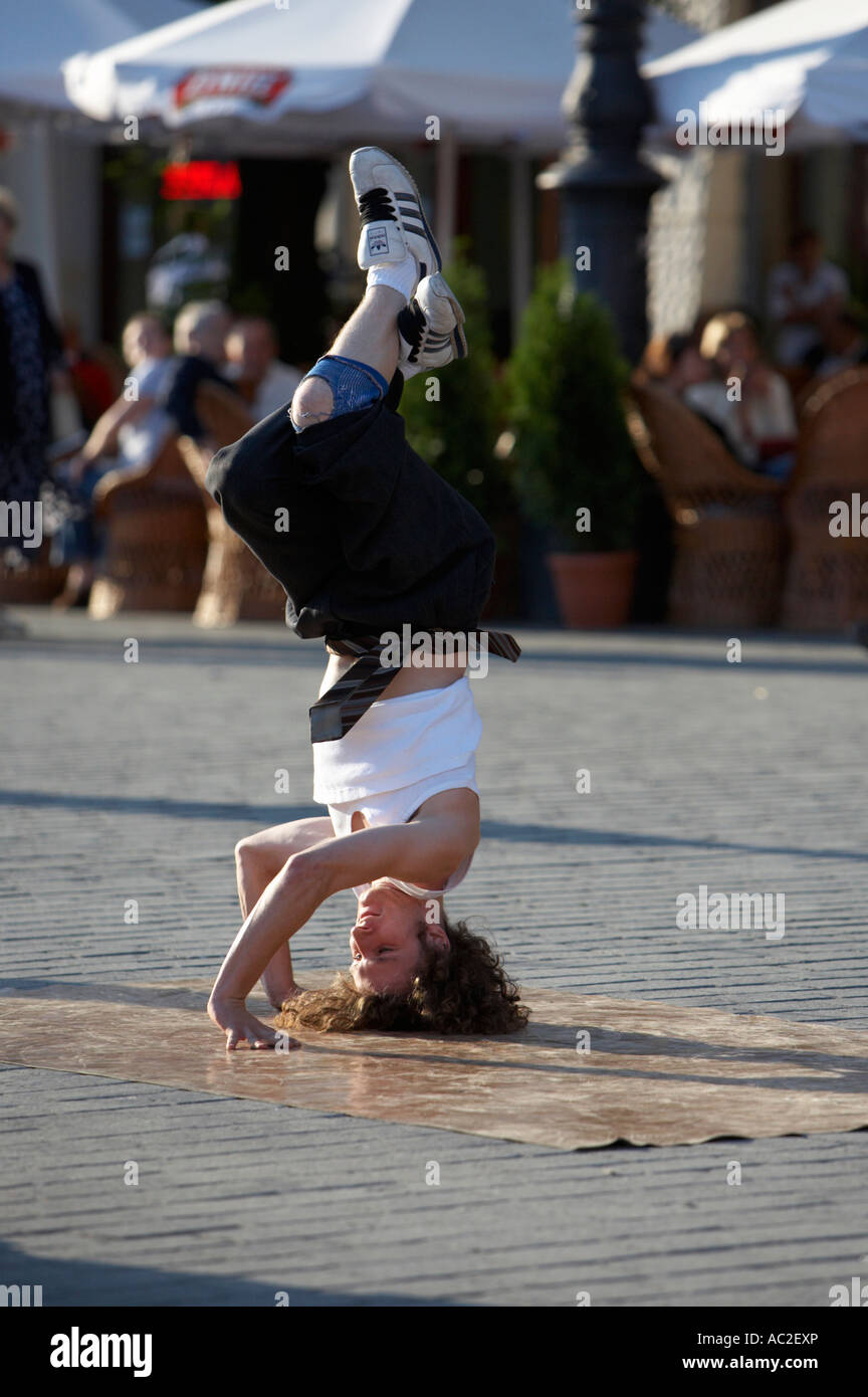 breakdancing young male street entertainer standing on his head in the ...