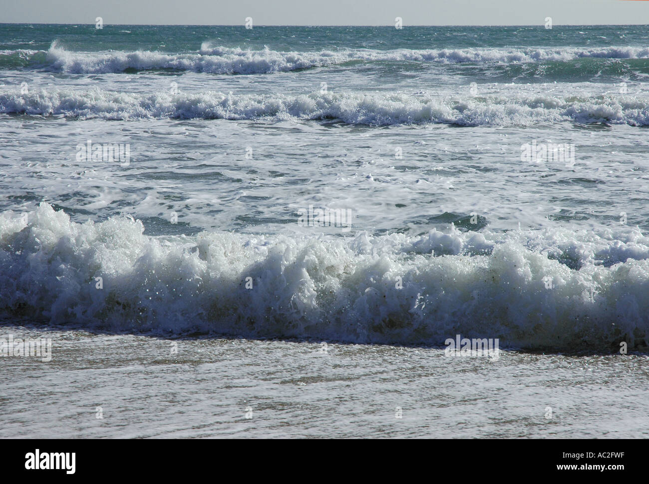 Small waves rolling into a shallow beach Stock Photo - Alamy